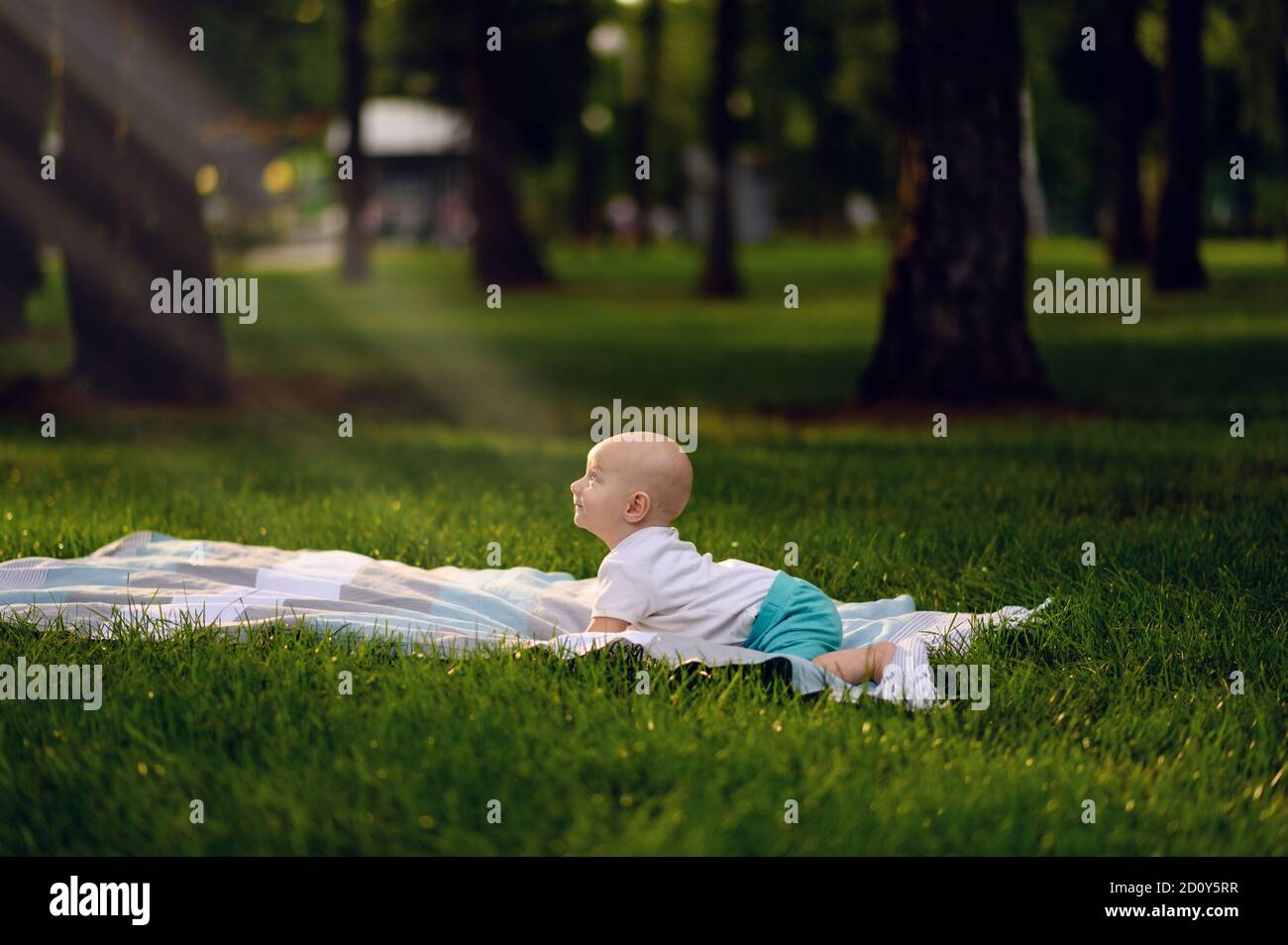 Little baby lying on grass in summer park Stock Photo - Alamy