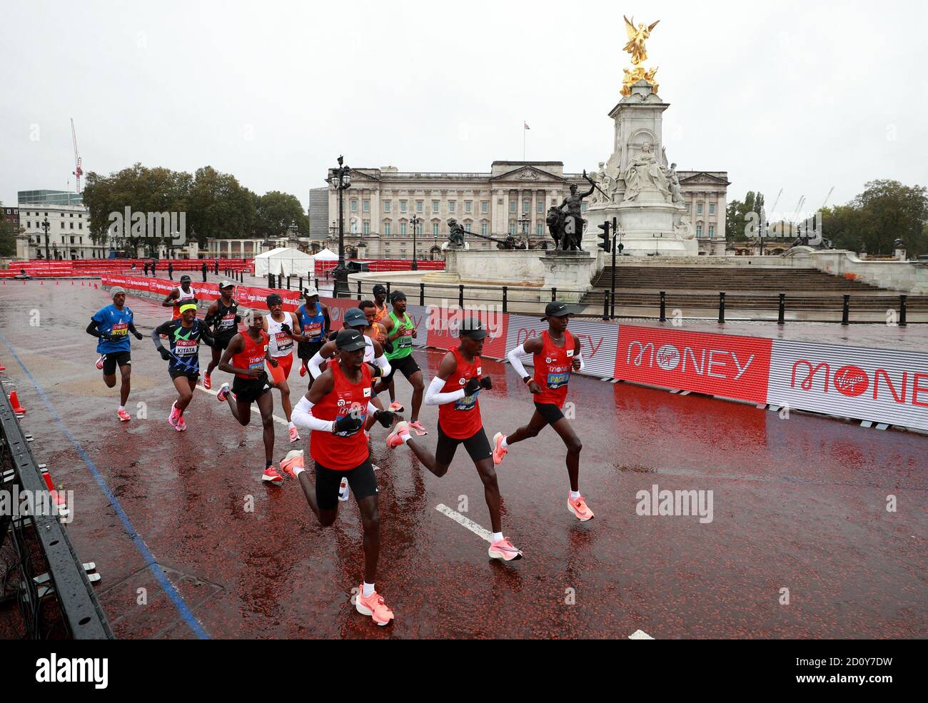 Athletes pass Buckingham Palace and the Queen Victoria Memorial during ...