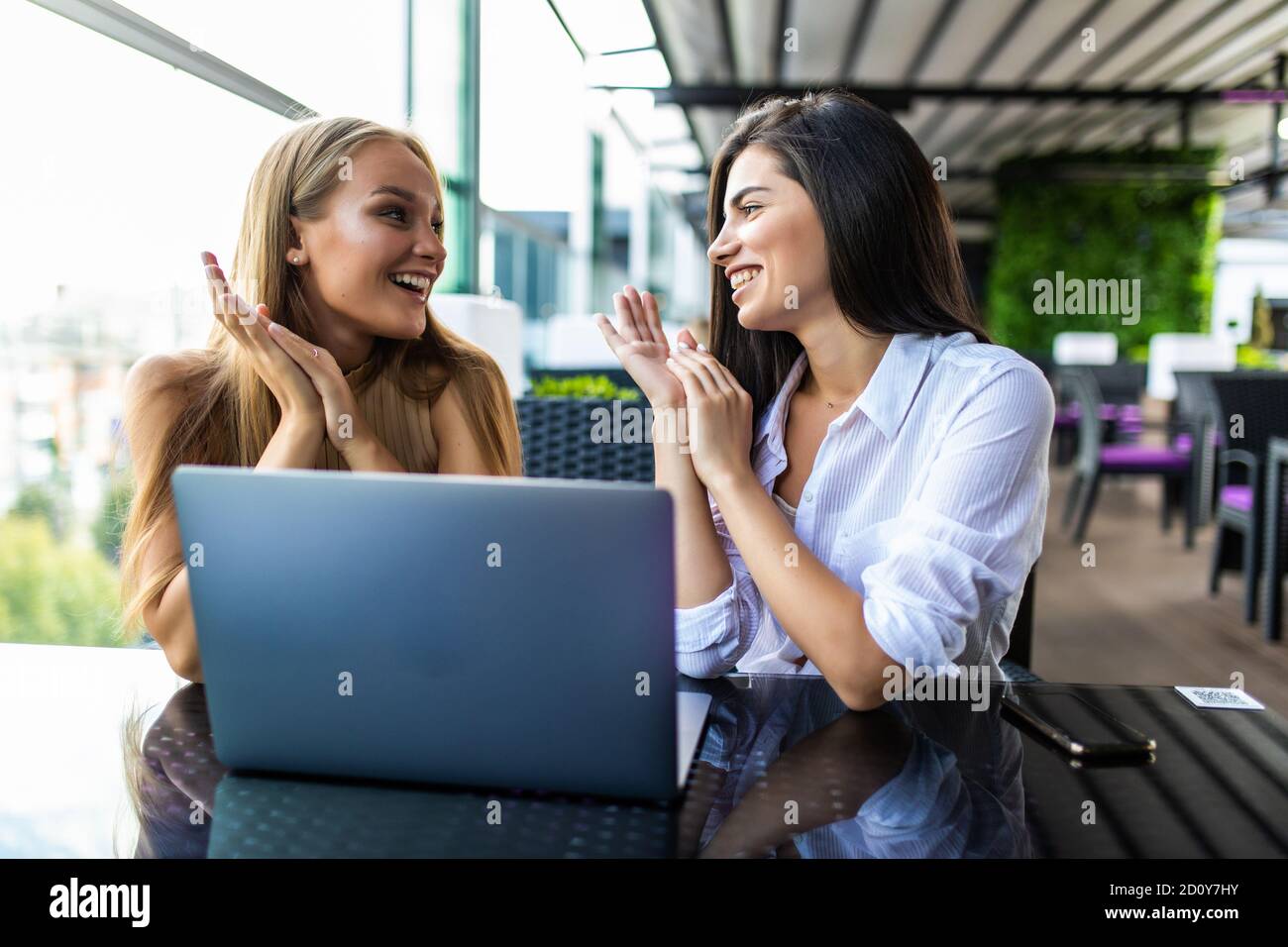 Two women using laptop computer in a coffee shop Stock Photo - Alamy