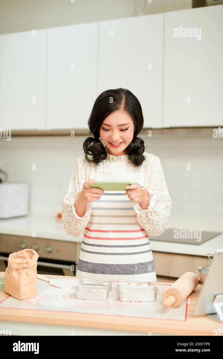 Beautiful woman make photo with fresh raw cake batter on a baking tray ...