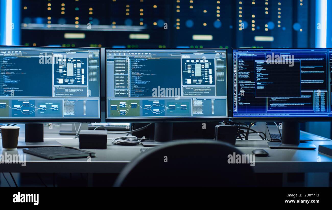 Shot Of Multiple Personal Computer Monitors Showing Coding Language Program With System
