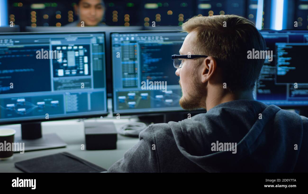 IT Specialist Working on Personal Computer with Monitors Showing Coding Language Program ...