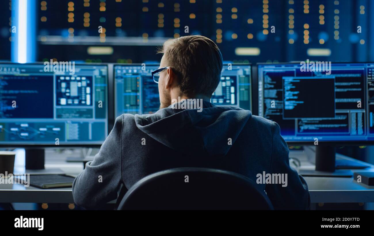 IT Specialist Working on Personal Computer with Monitors Showing Coding Language Program ...