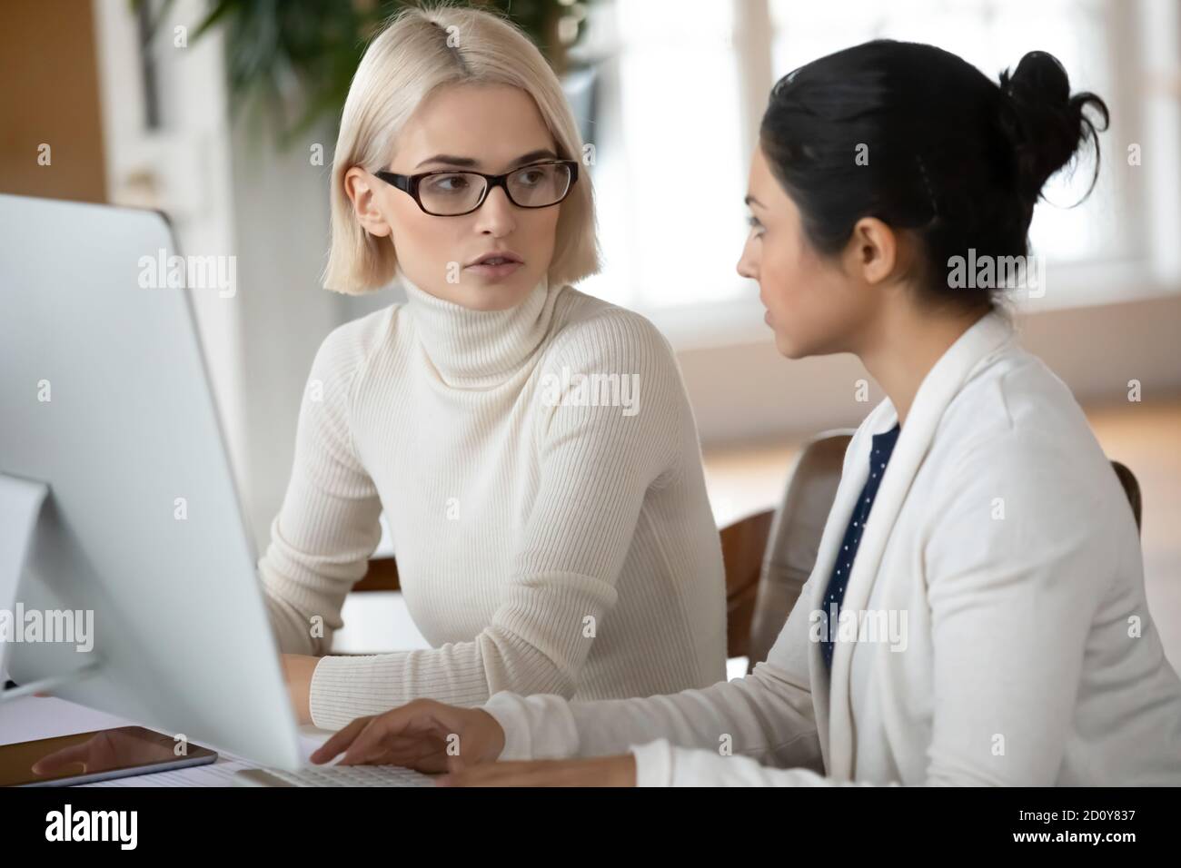 Multiracial female colleagues brainstorm working at computer Stock ...