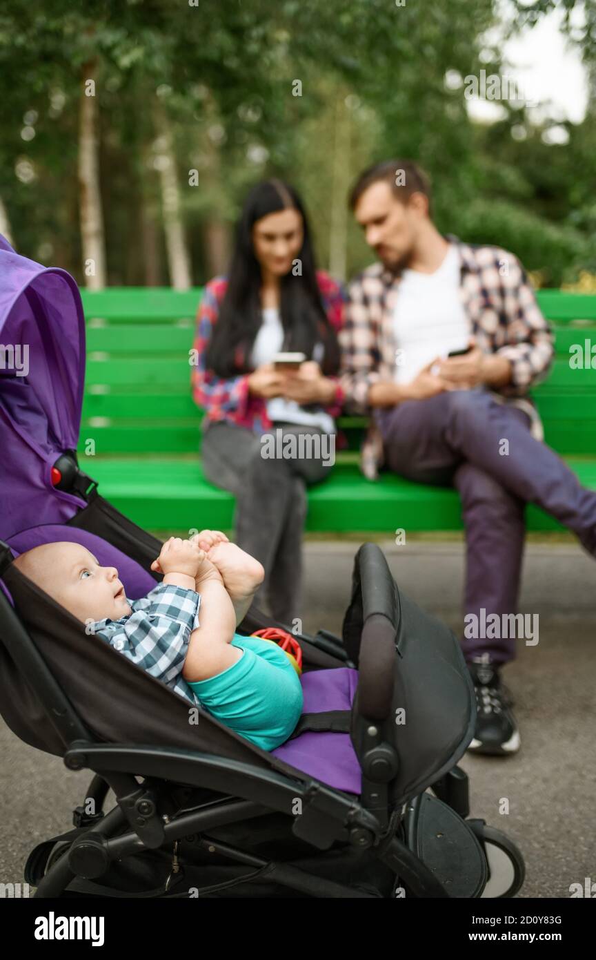 Parents using phones while walks with little baby Stock Photo - Alamy