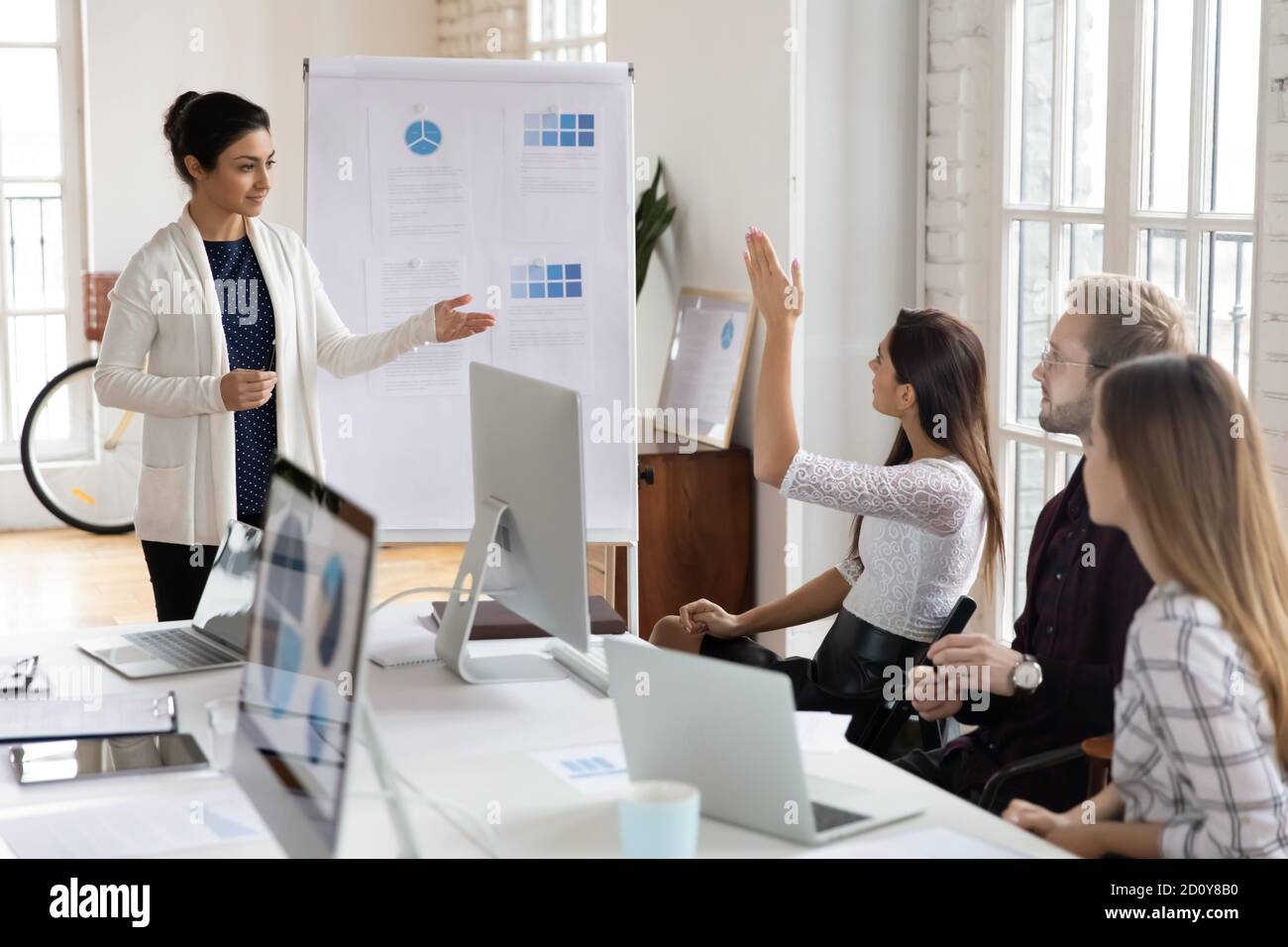 Indian female speaker interact with employee raising hand Stock Photo ...