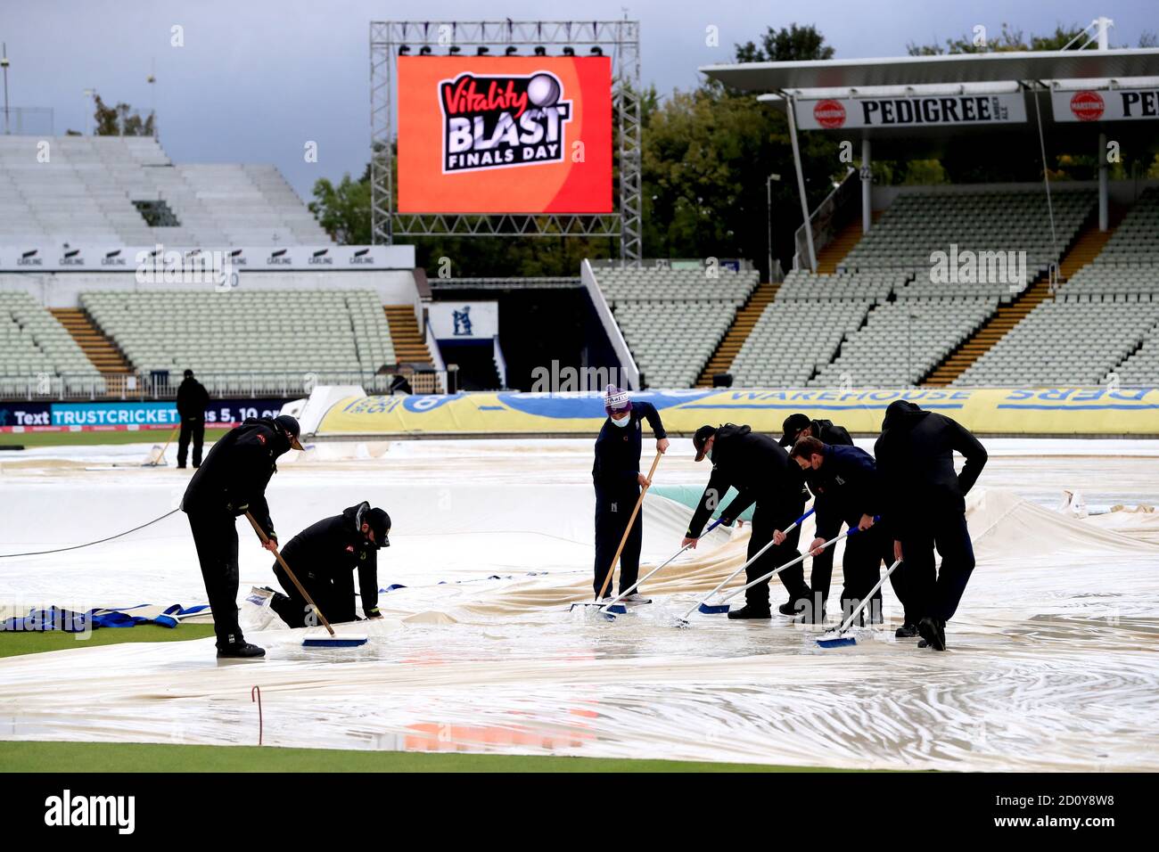 Ground staff sweep water off hi-res stock photography and images - Alamy