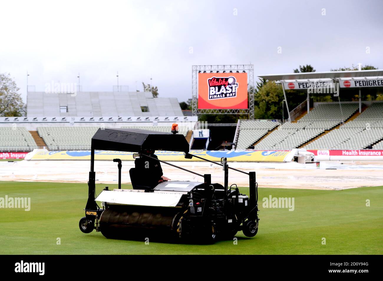 Ground staff operate the blotter machine as rain delays the start of ...