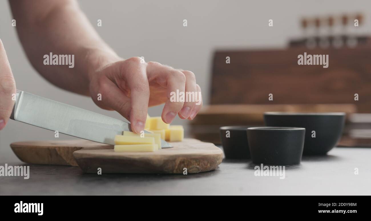 man cutting hard cheese with knife on wood board, wide photo Stock ...