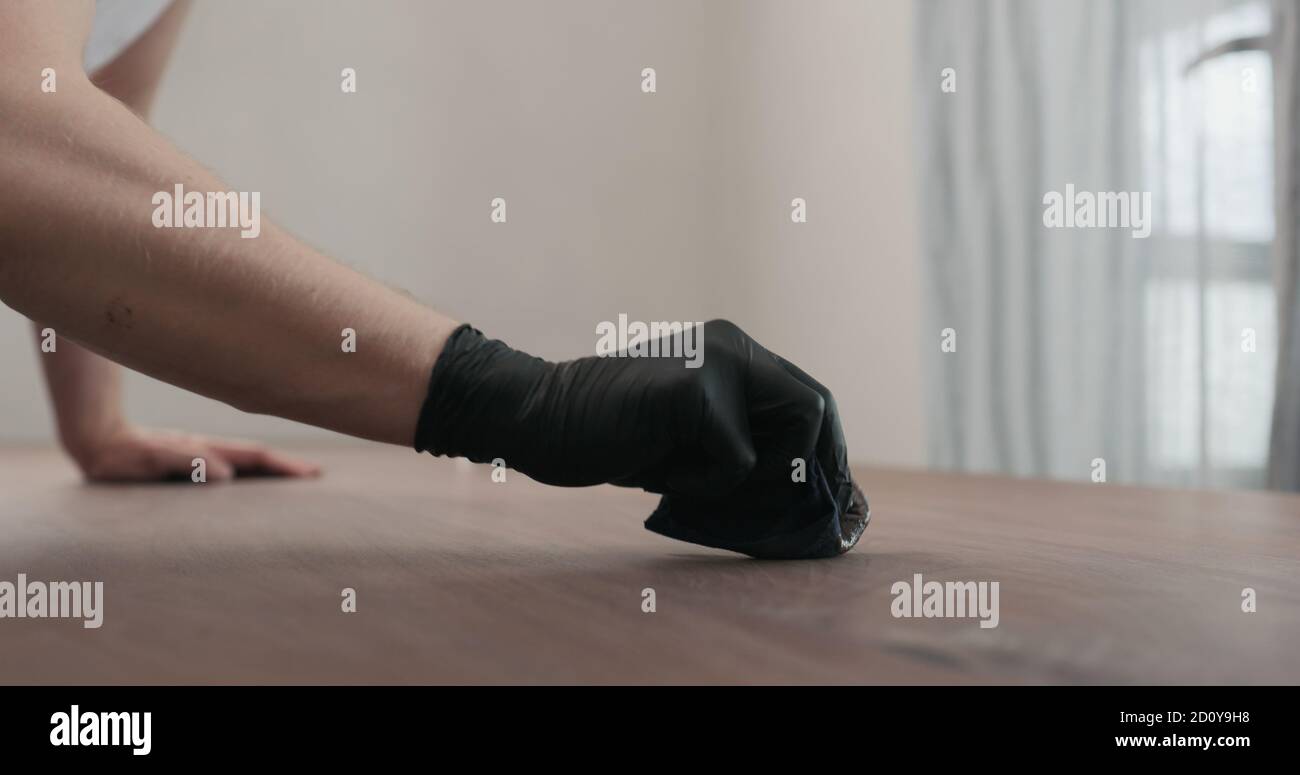 man hand applying oil finish to toned walnut table with cloth, wide ...