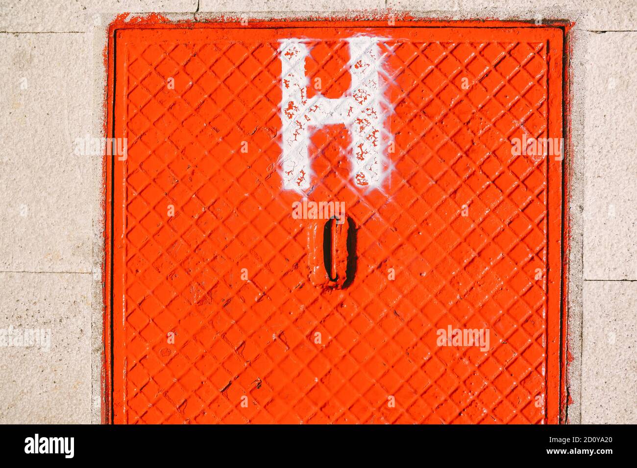 Bright red square floor hatch with a large white H Stock Photo - Alamy