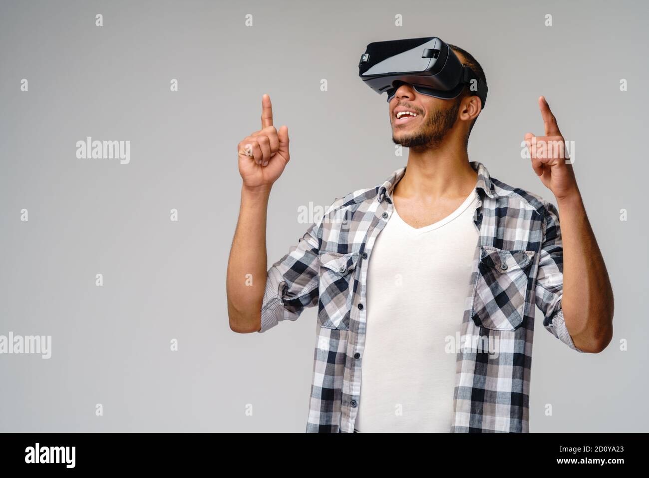 Young African-American young man wearing vr virtual reality headset ...