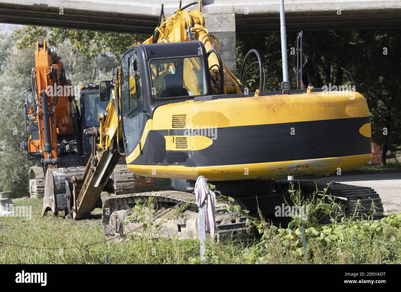 View of two backhoes prepared for contraction under a bridge Stock ...