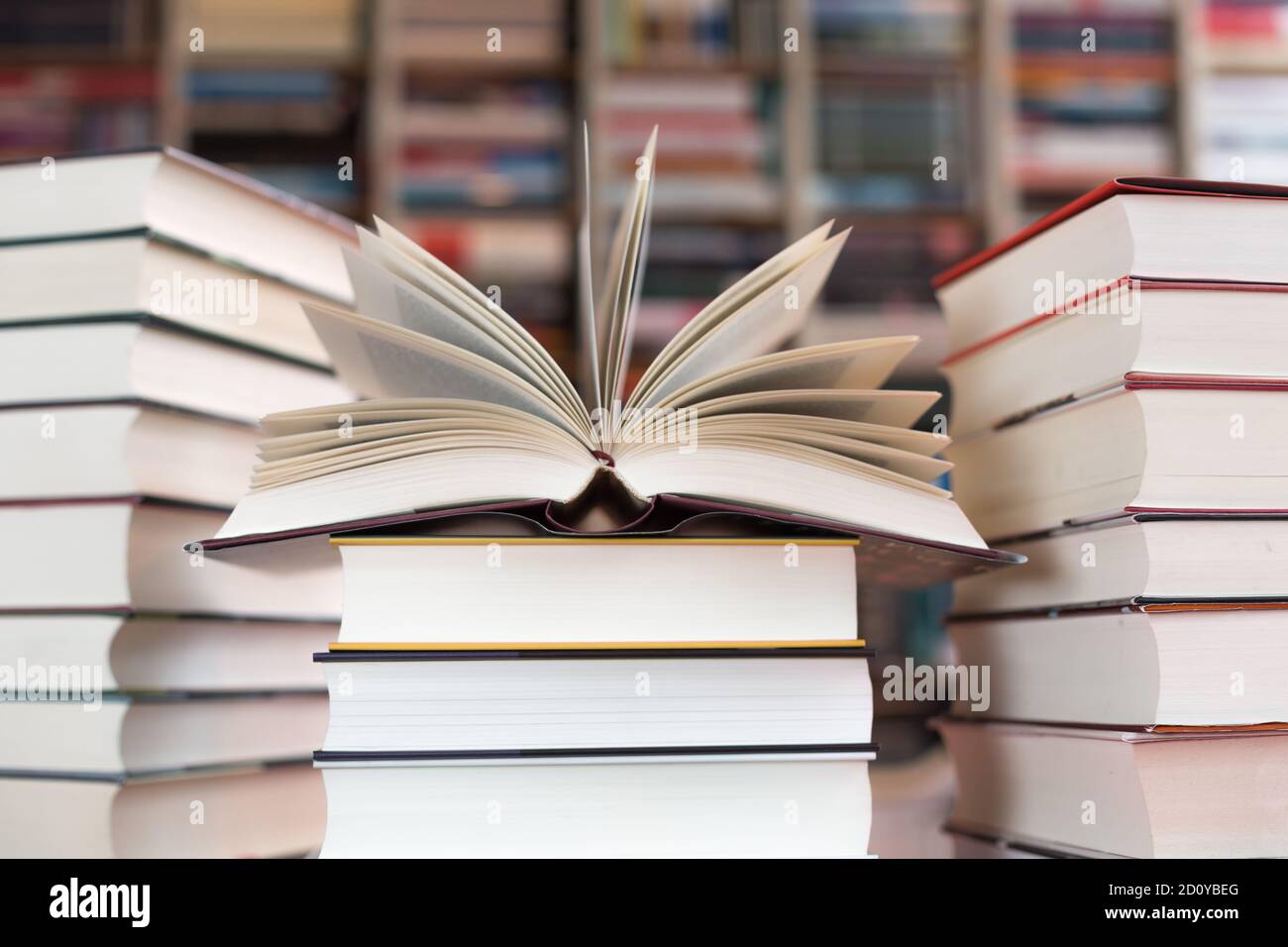 open novel between book stacks Stock Photo - Alamy