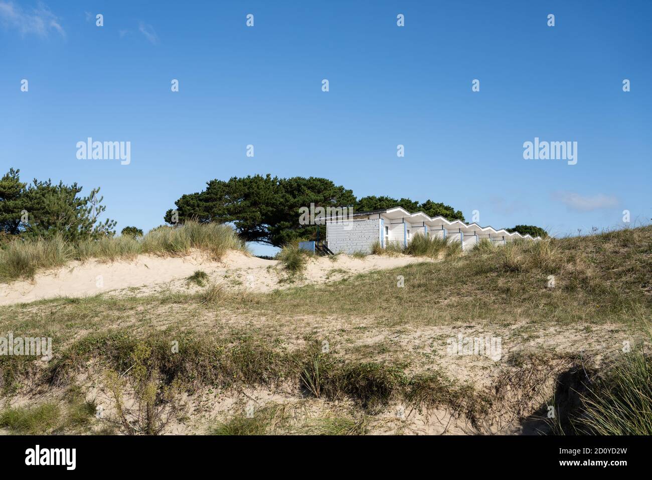 Beach huts through the sand dunes at Sandbanks Stock Photo - Alamy