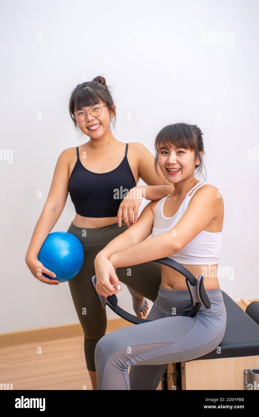 Two young happy Asian women posing and smiling for camera during their ...