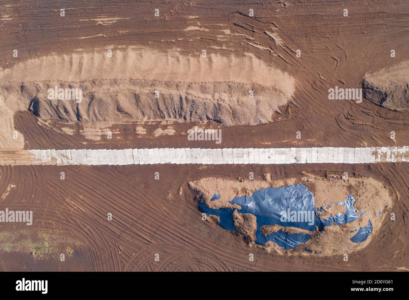 Aerial top down view of peat harvesting field with piles of peat. Peat ...