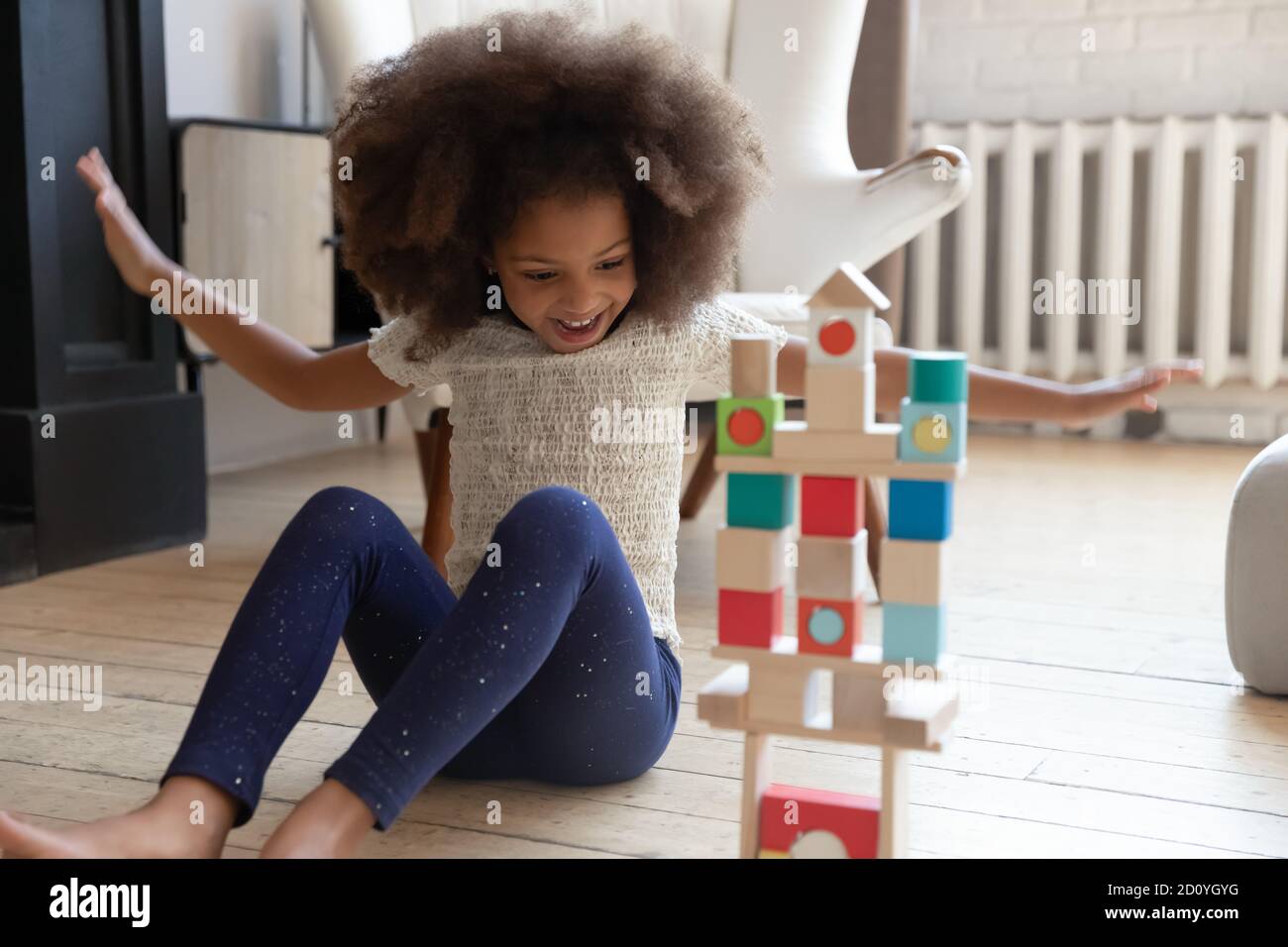 Overjoyed young funny adorable child girl finishing constructing toys ...