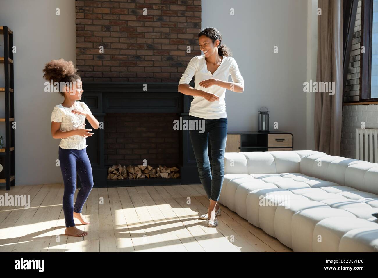 Small kid girl repeating funny disco moves after mother Stock Photo - Alamy