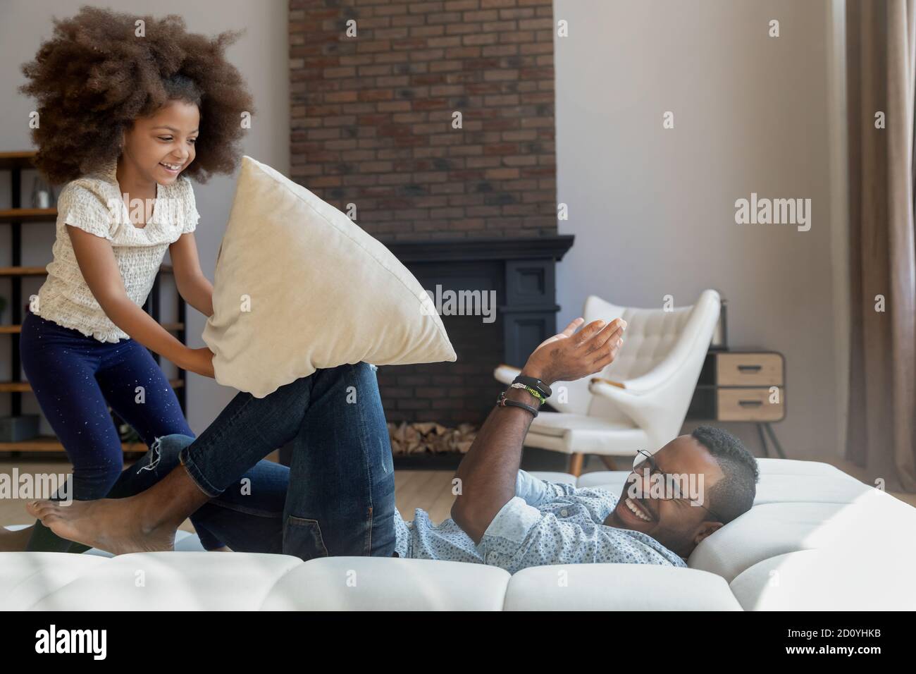 Overjoyed different generations african american family playing pillow ...