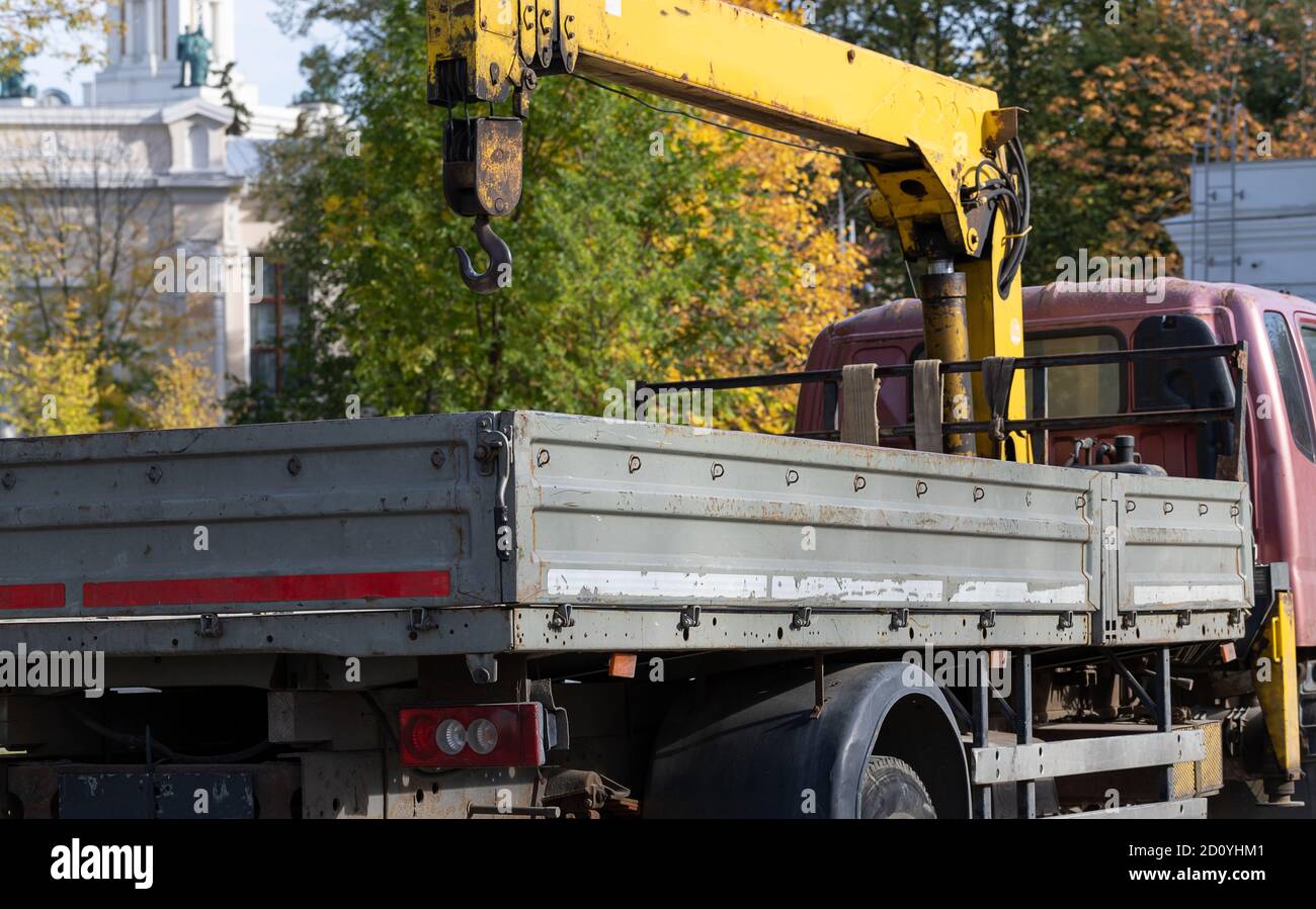 Small truck with loader crane for unloading construction materials at a ...