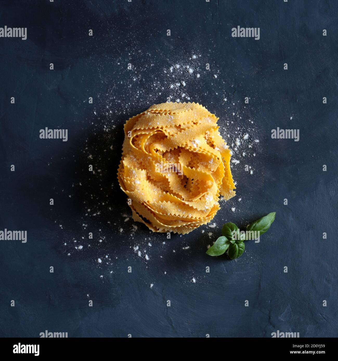 Italian pasta. Curly pappardelle pasta on dark background. View from ...