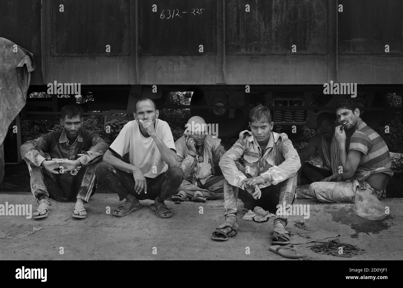 Manual workers employed to move heavy bags of cement enjoy a break ...