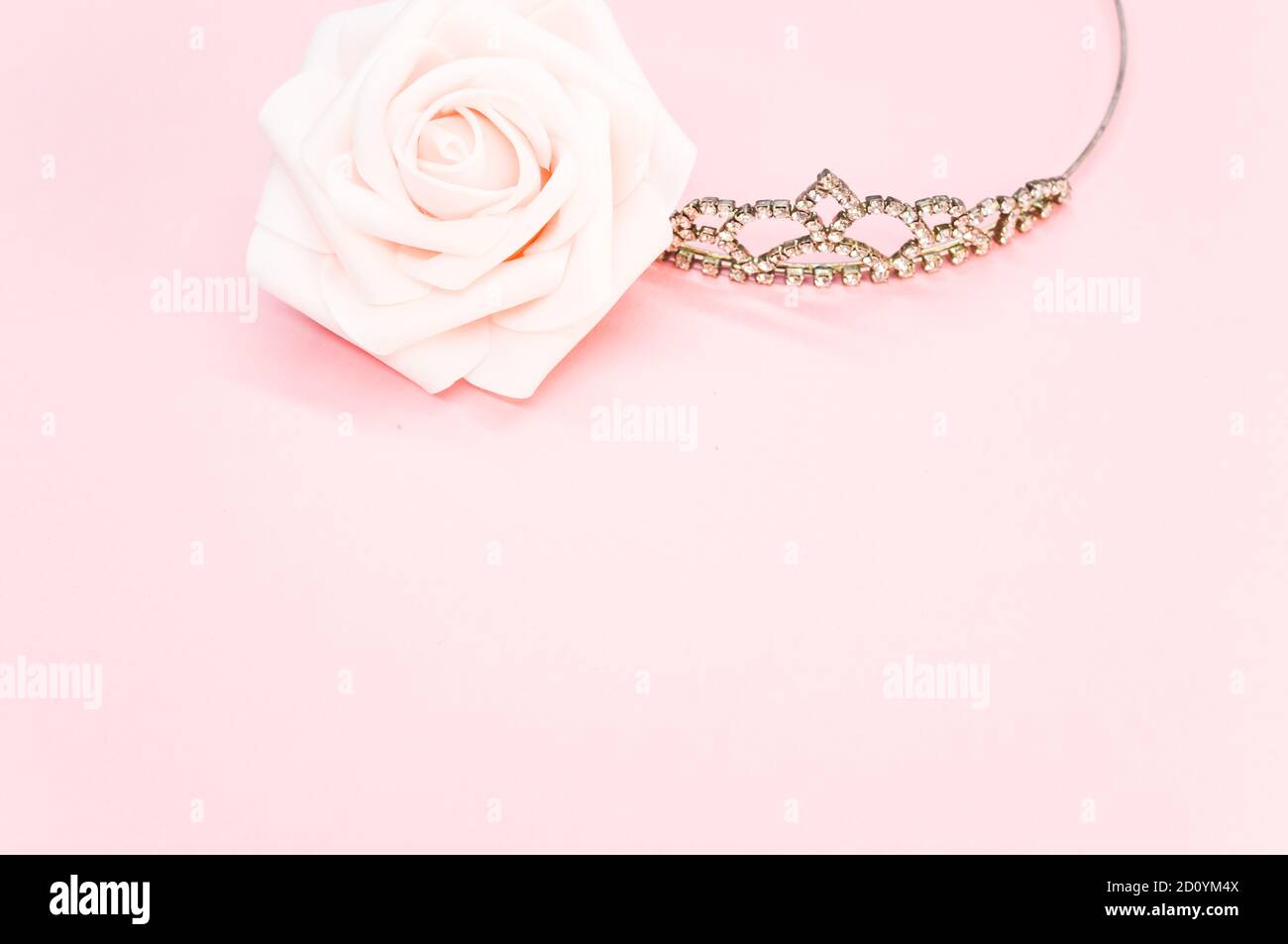 Elegant crown next to a decorative rose on pastel pink background Stock ...