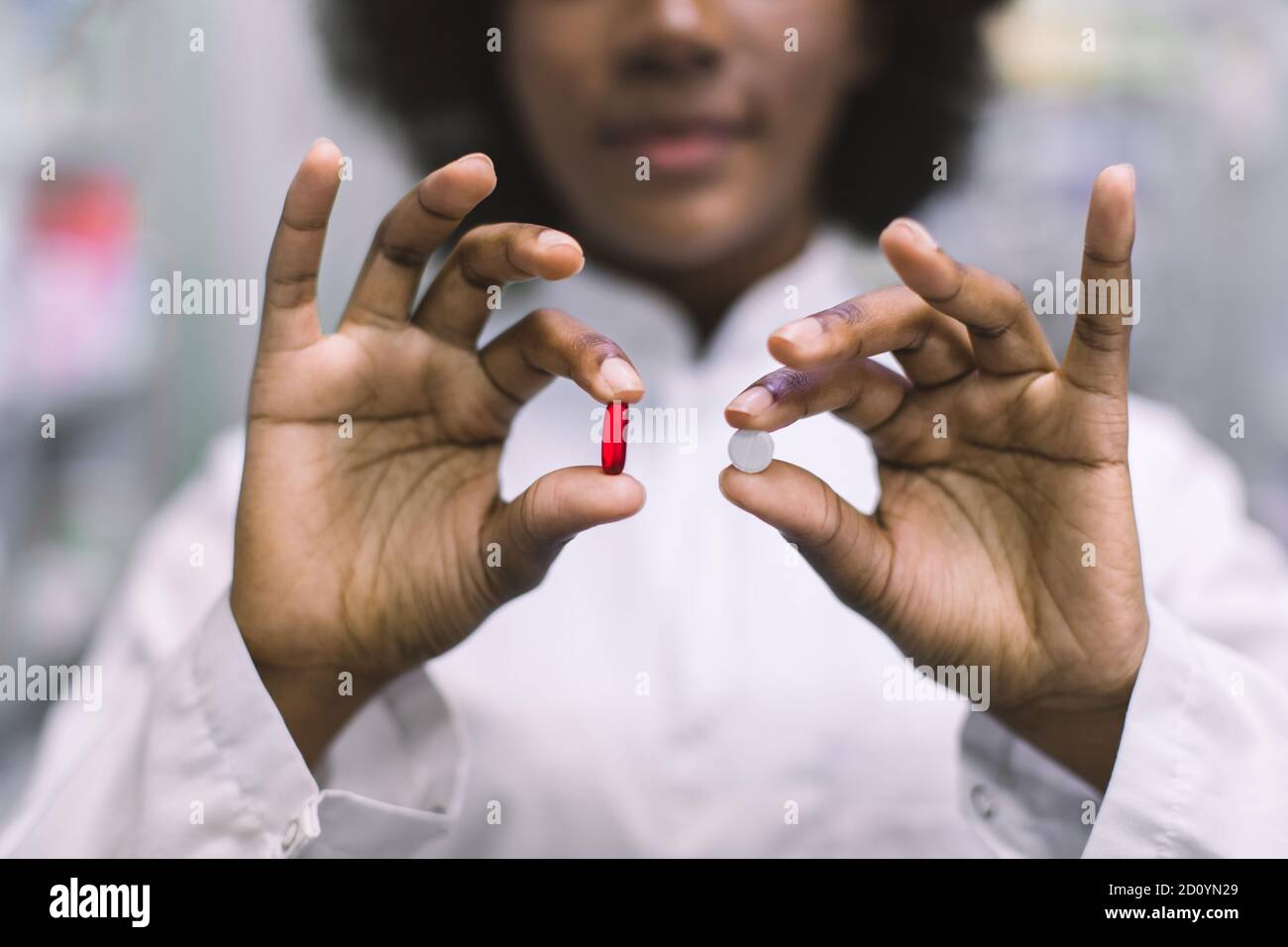 Young smiling African woman doctor or clinical pharmacist holding white ...