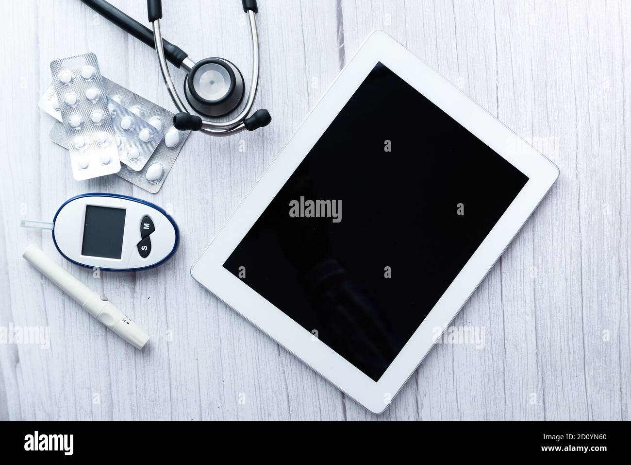 top view of digital tablet, pills and diabetic measurement tool on ...