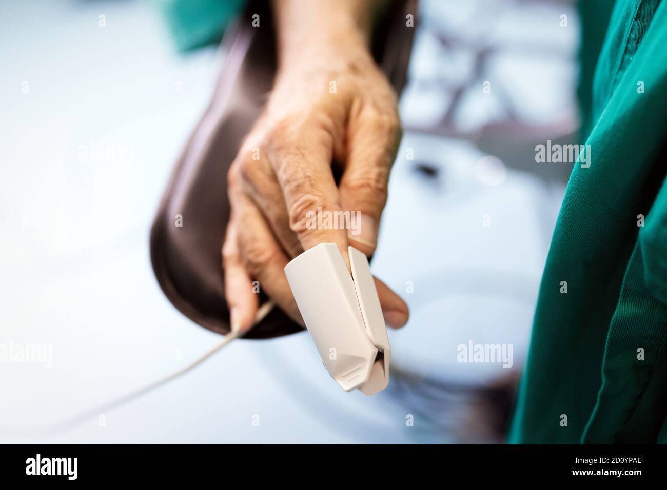 Patient with pulse oximeter on finger for monitoring during surgery ...