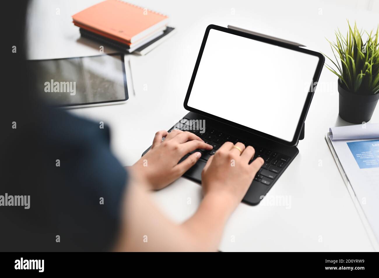 A close-up image of a woman is using a computer tablet at the white ...