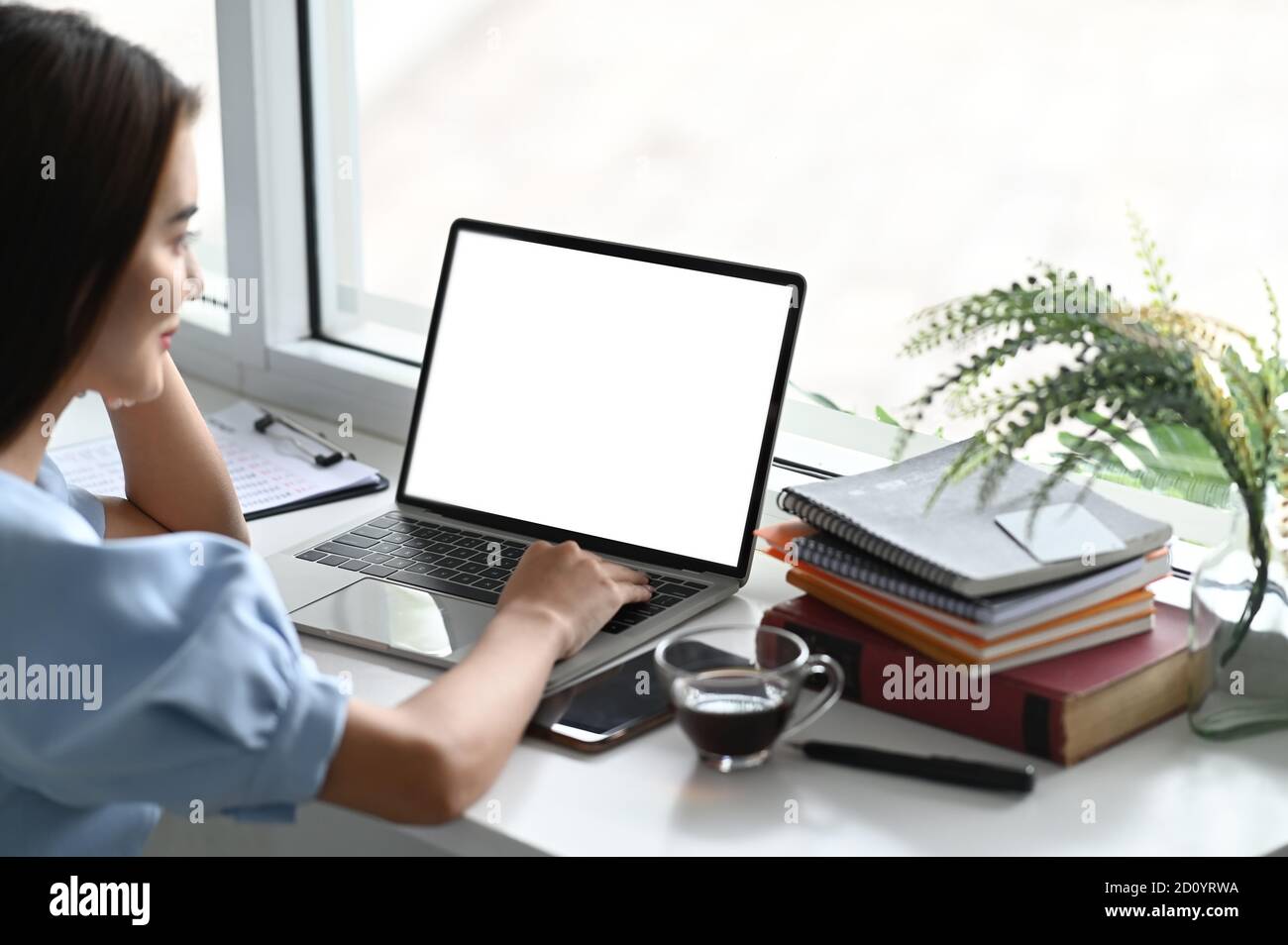 A close-up image of a woman is using a computer laptop at the white ...