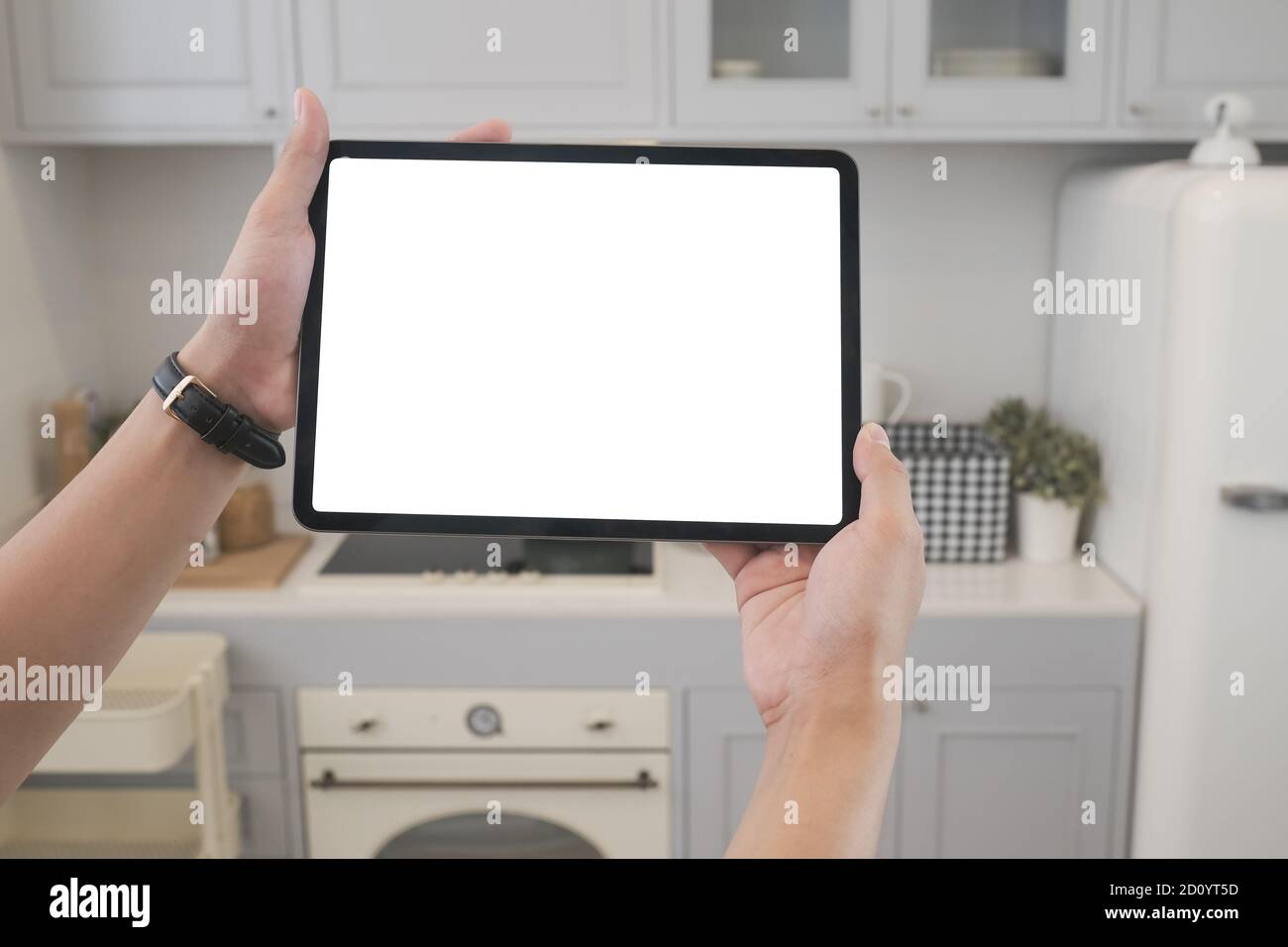 Man's hands holding digital tablet empty screen in kitchen room Stock ...