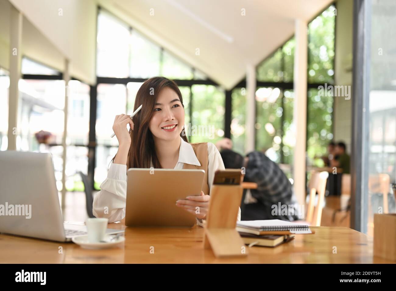 Beautiful confident woman looking at her tablet concentrate on it while ...