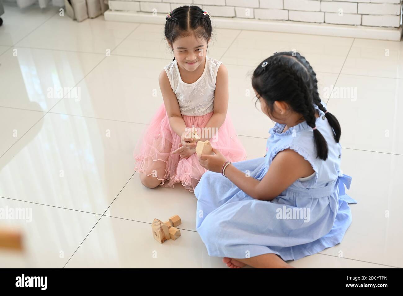 Two kids playing with wood blocks together at home or daycare Stock ...