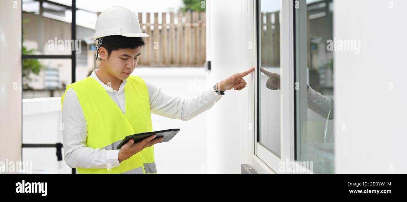 Construction worker using digital tablet with check house building ...