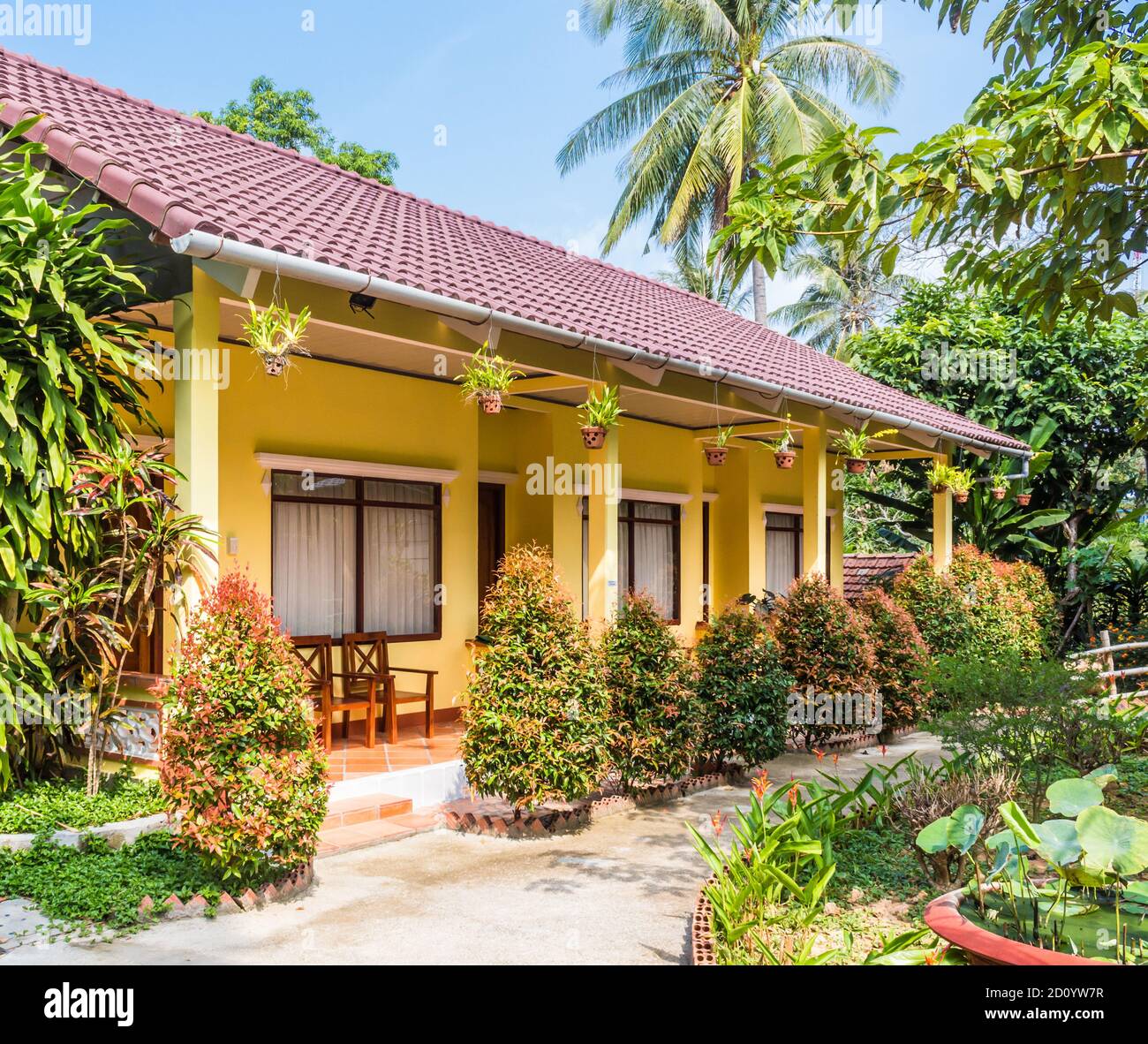 small yellow hotel building in tropical resort Stock Photo - Alamy