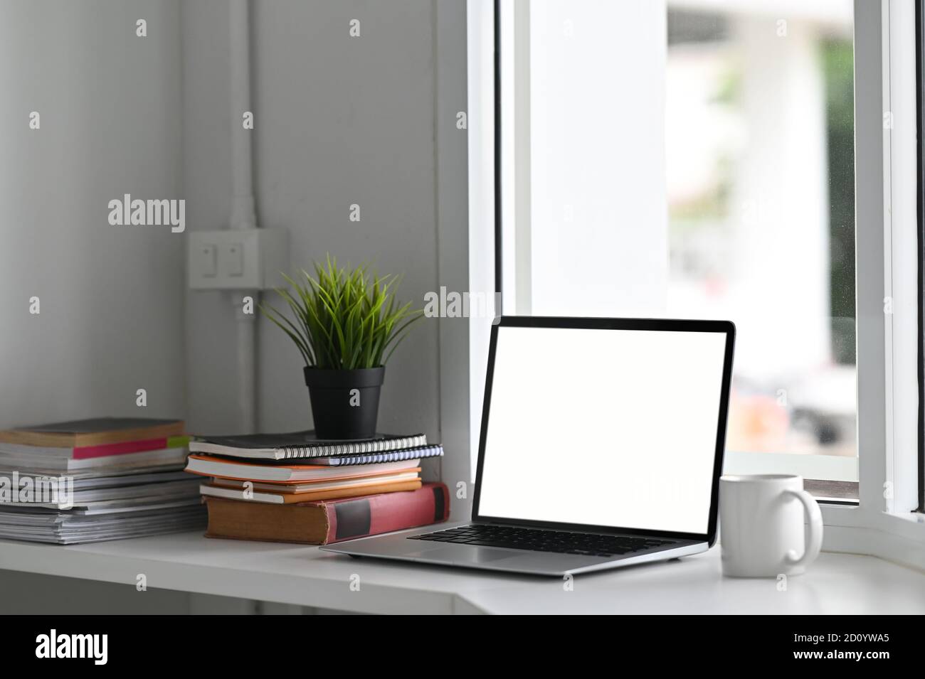 Minimal workspace with blank screen laptop computer and book on white ...