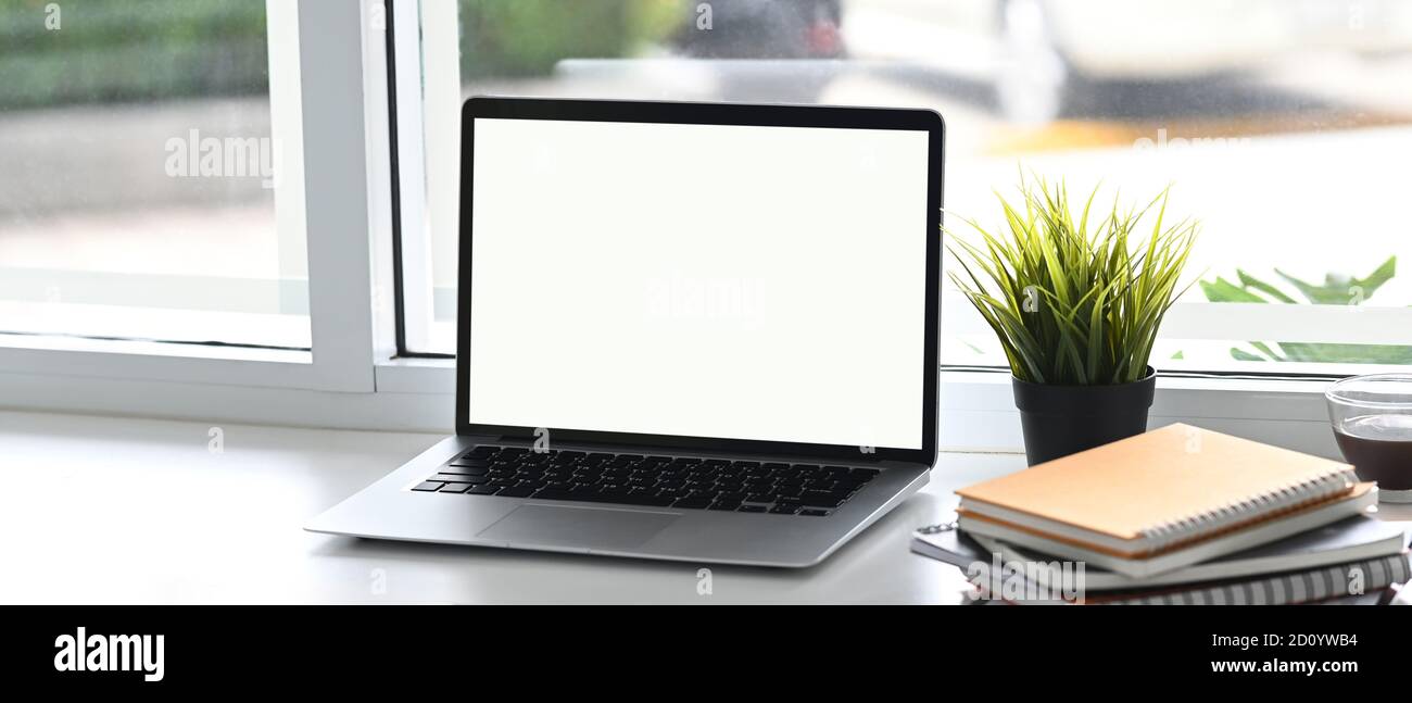 Minimal workspace with blank screen laptop computer, note book and ...
