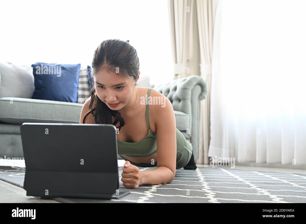 Attractive woman learning new exercises watching online workout ...