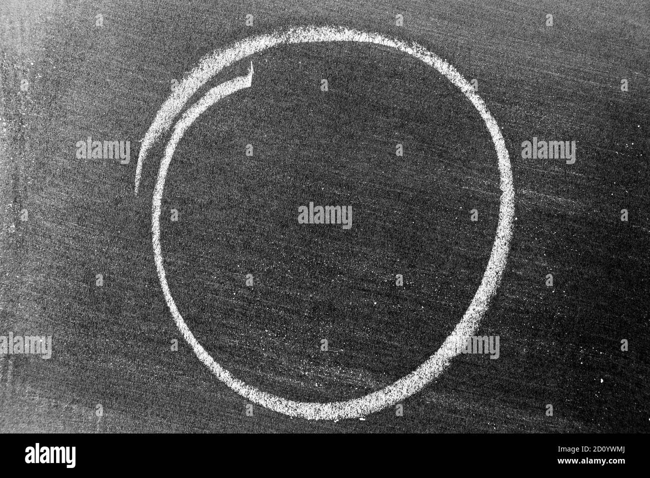 White color chalk hand drawing in circle or oval shape on black board ...