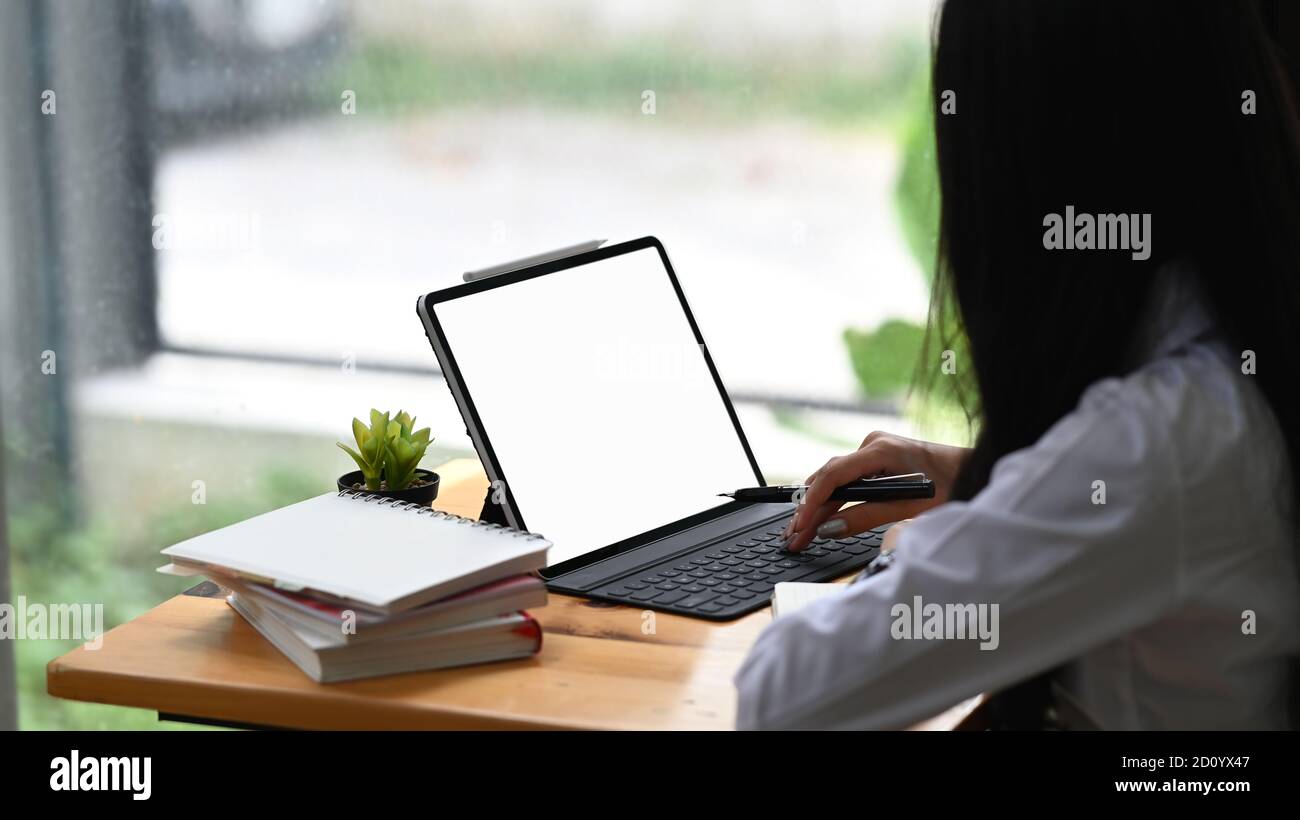Side view of bussinesswoman hands holding pen and typing on keyboard ...