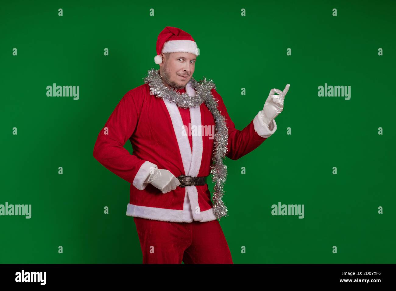 Male actor in a costume of Santa Claus gesturing and posing on a green ...