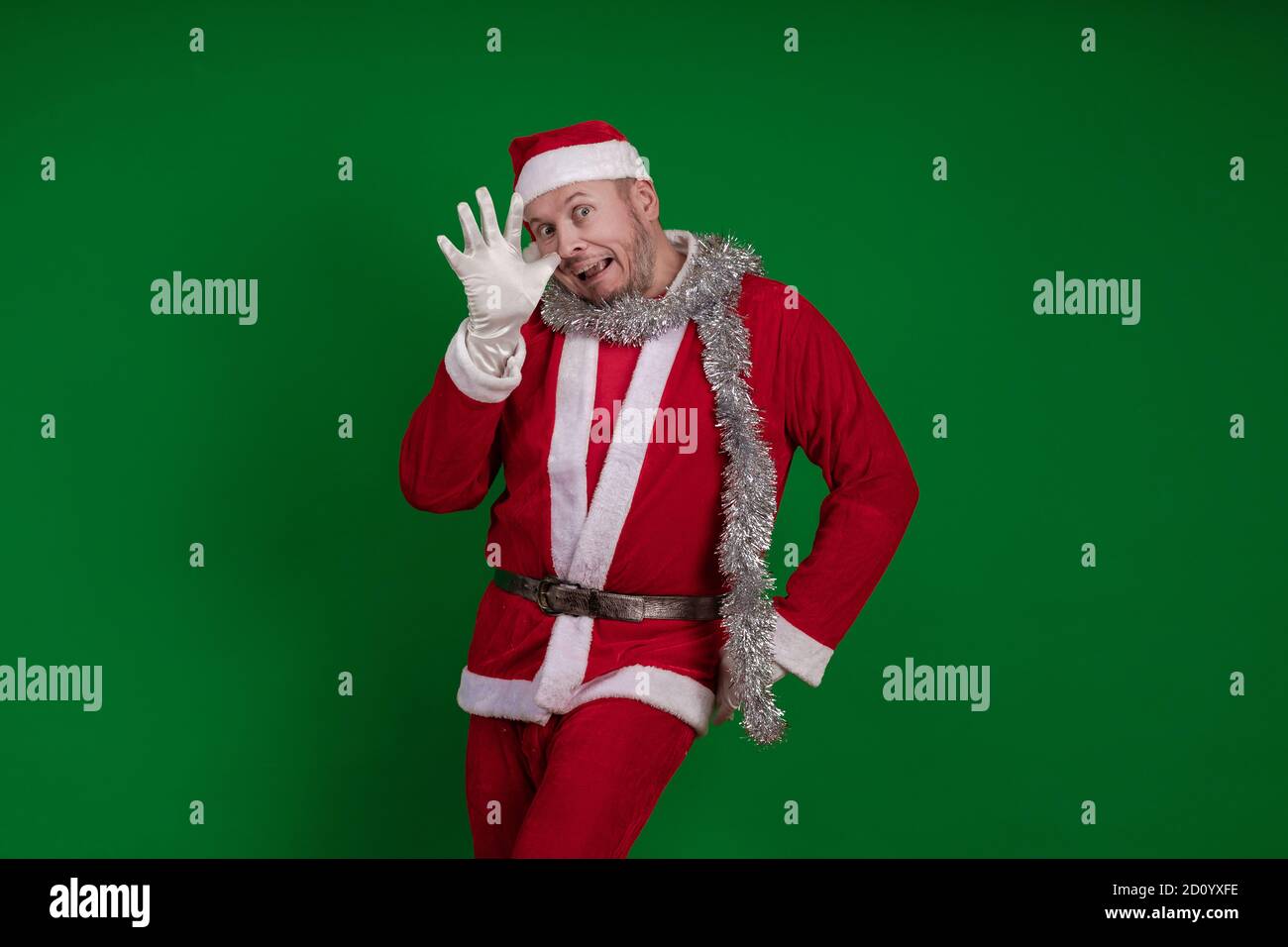 Male actor in a costume of Santa Claus gesturing and posing on a green ...