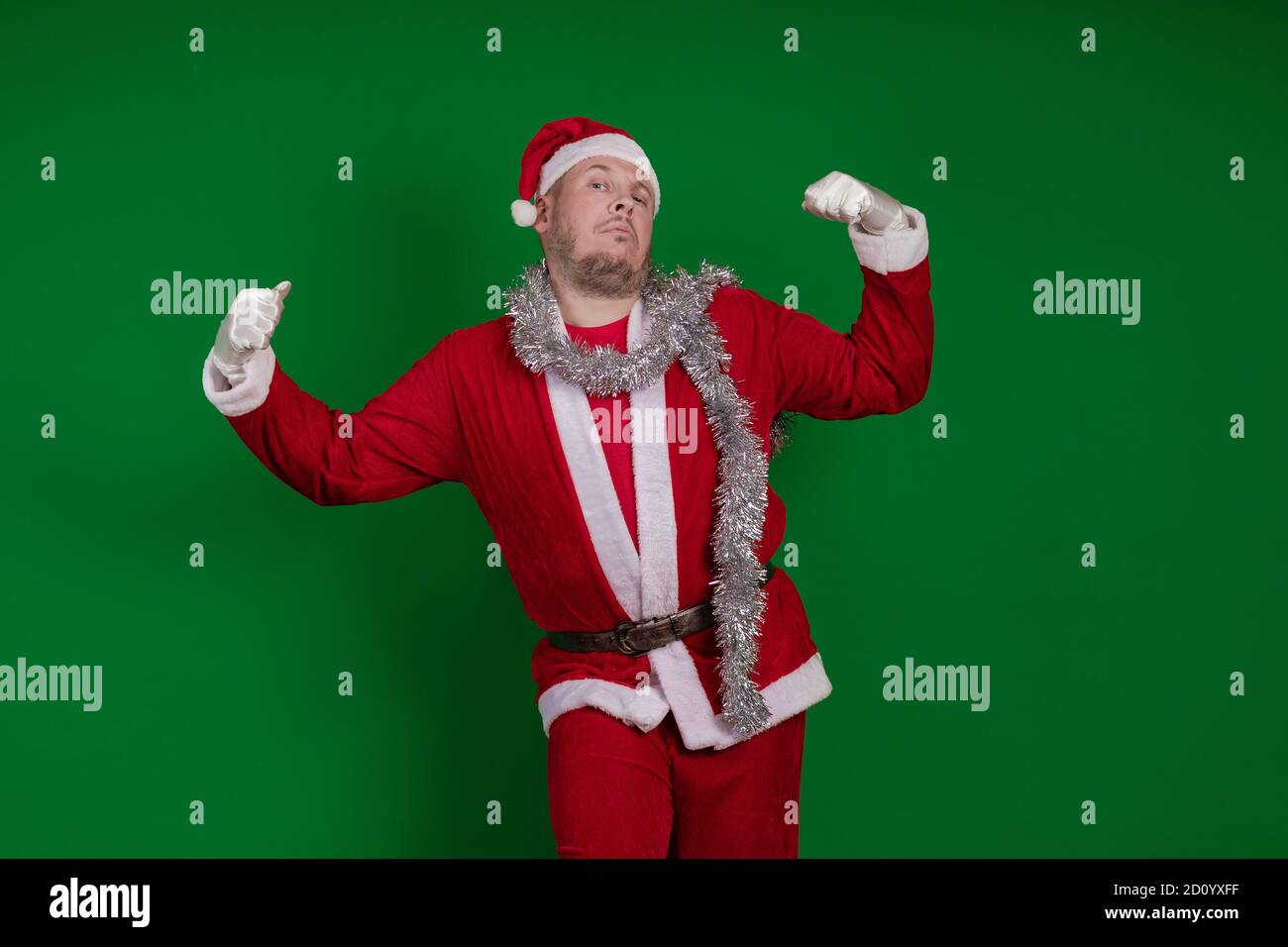 Male actor in a costume of Santa Claus gesturing and posing on a green ...