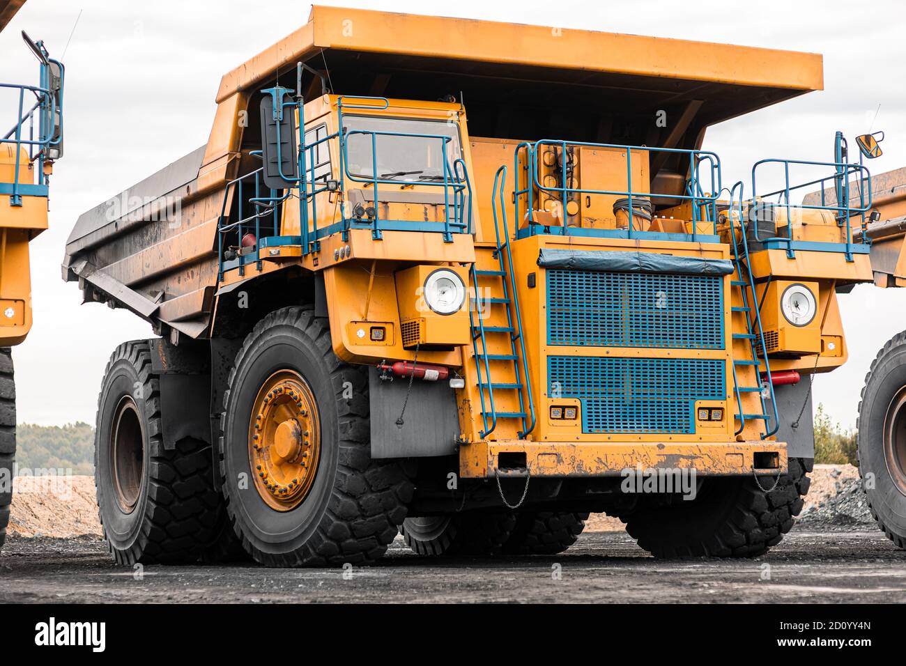 Large quarry dump truck. Big yellow mining truck at work site. Loading coal into body truck ...