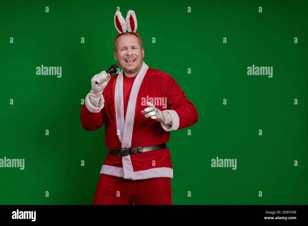 Emotional male actor in a costume of Santa Claus sings and speaks into ...