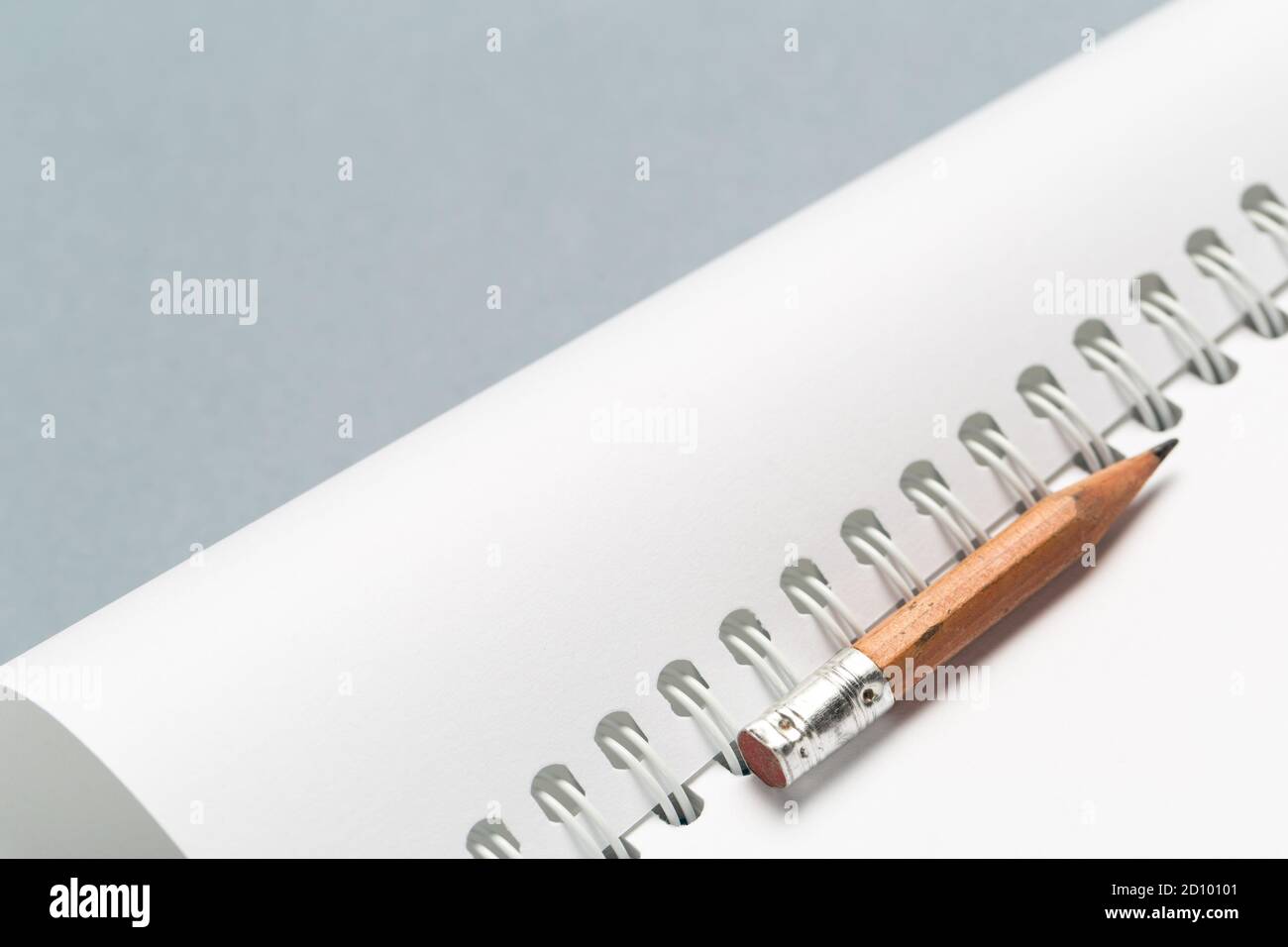 Short worn pencil with notepad on gray desk Stock Photo - Alamy