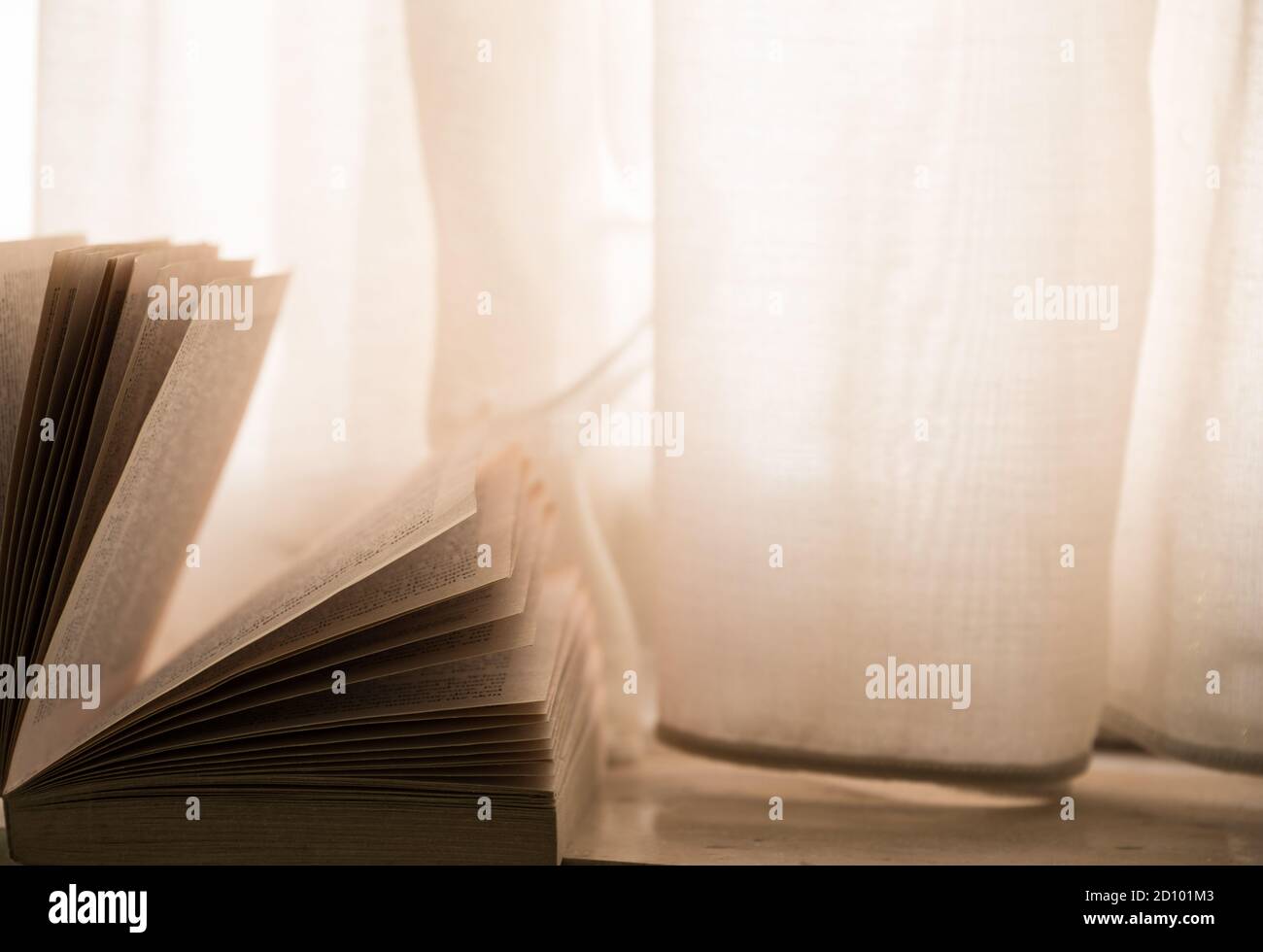 Open book on window sill, with curtains and warm light Stock Photo - Alamy